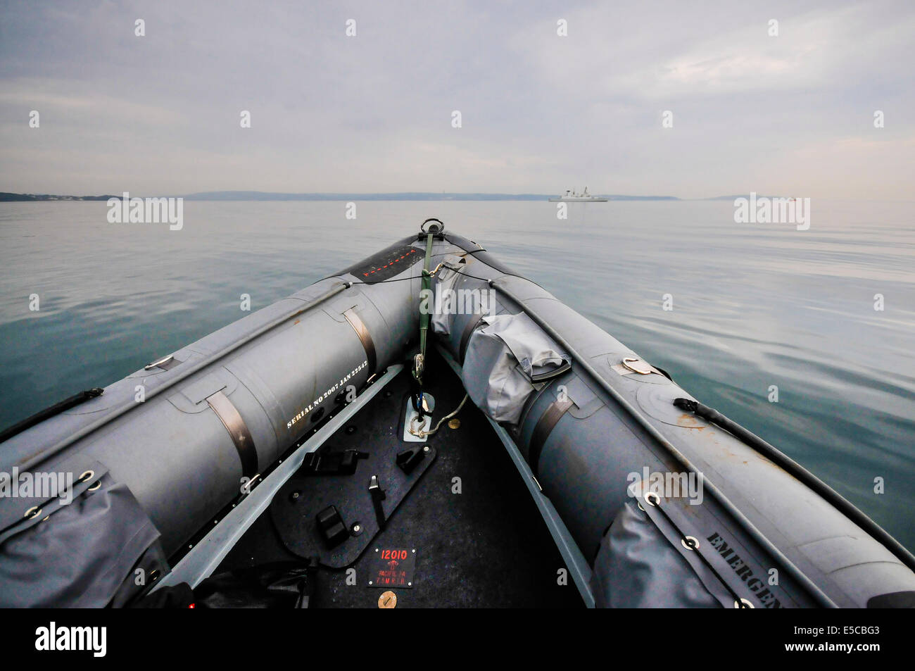 A Reinforced Inflatable Boat (RIB) is driven at speed across a flat sea ...