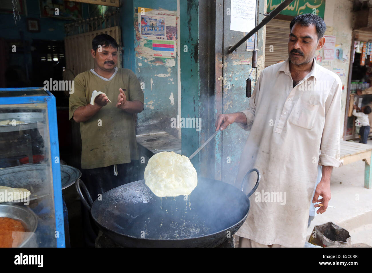 making Roti, in hot oil fried traditional bread made in a small shop in ...