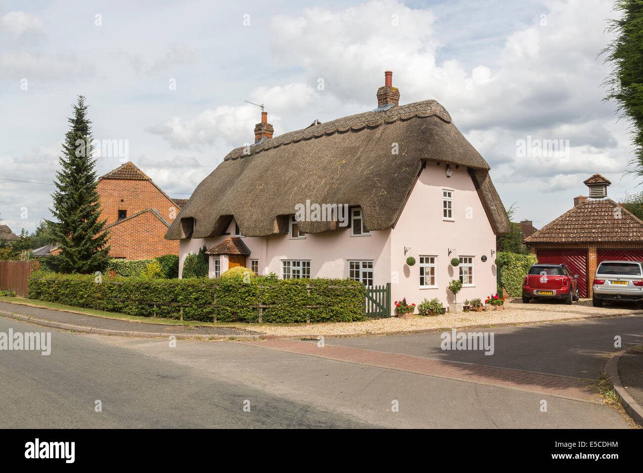 Pretty pink traditional thatched cottage in the country village of ...