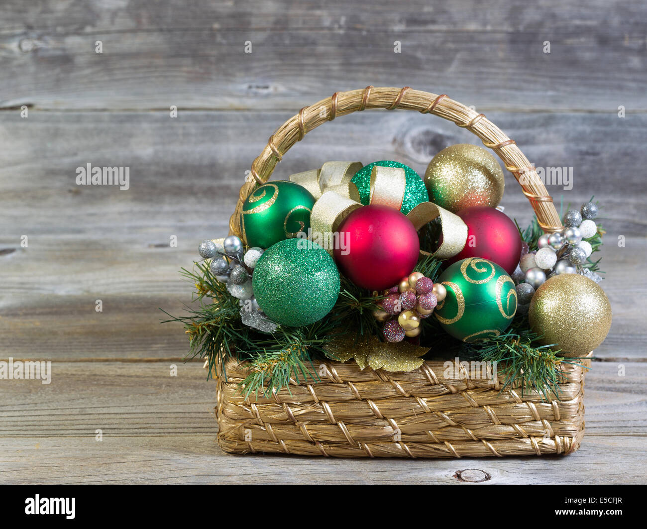 Front view of a basket filled with Christmas ornaments on rustic wood ...