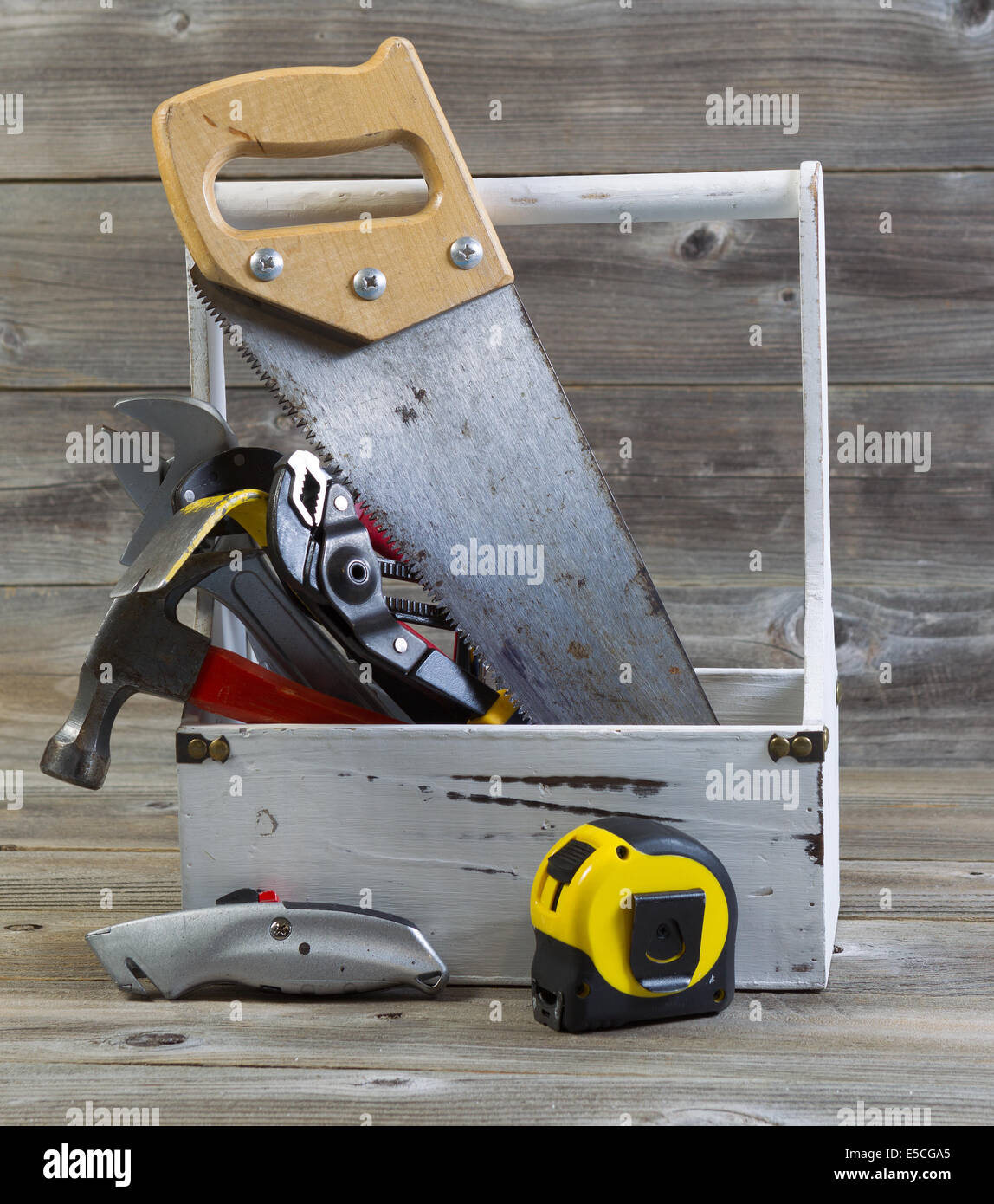 Vertical view of an old tool holder containing basic home repair tools ...