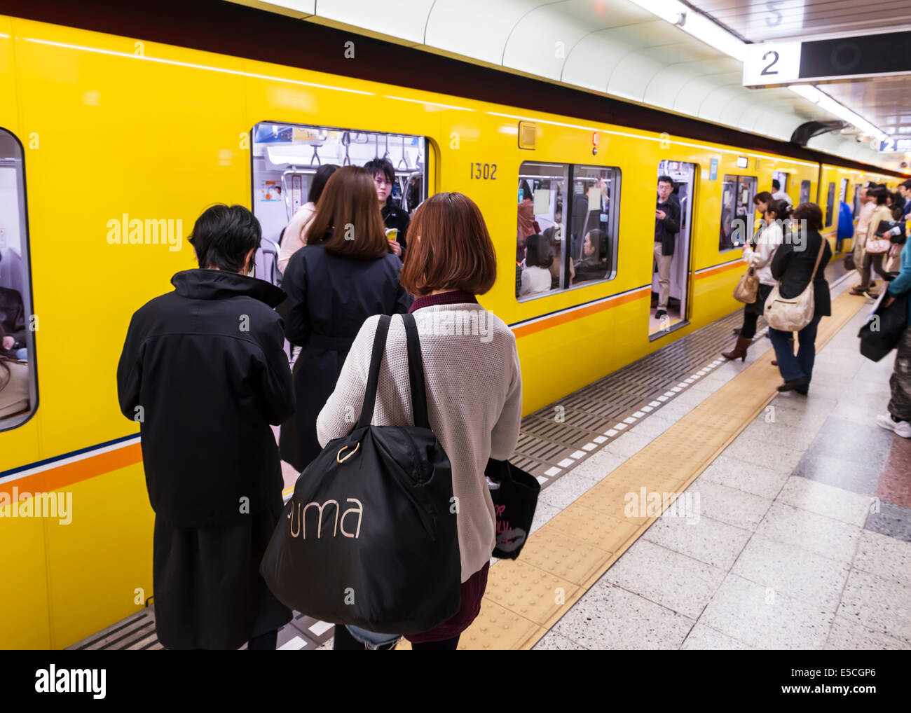 People at a subway station platform entering a train. Tokyo Metro ...