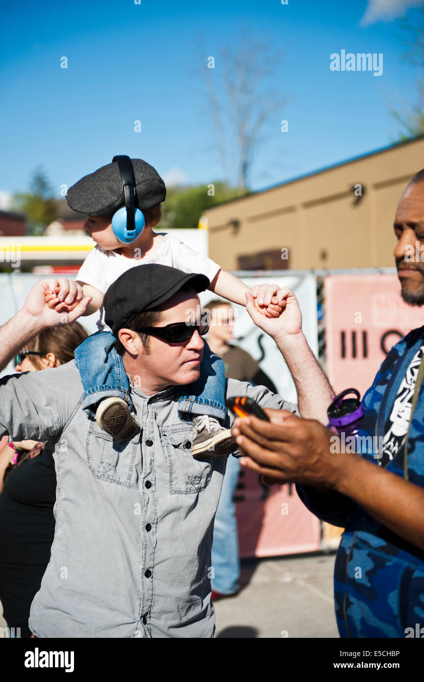 A man with young boy wearing head phones on his shoulders Stock Photo ...