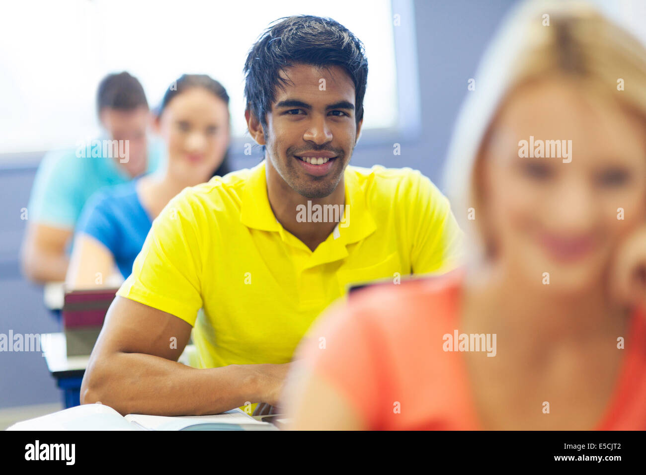 handsome male Indian college student in lecture room with classmates ...