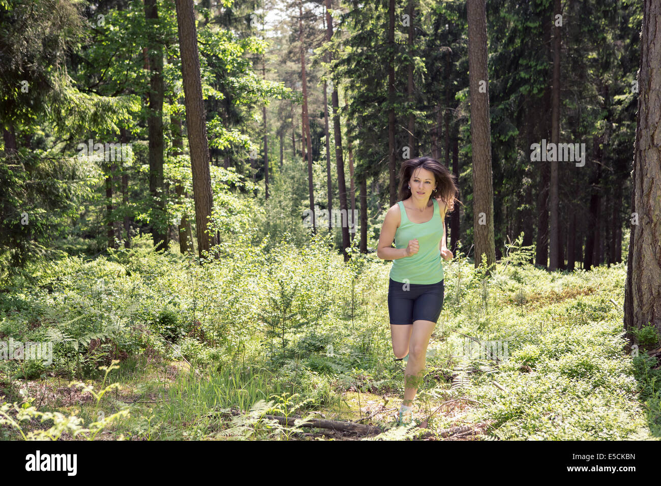 young woman jogging in a forest Stock Photo - Alamy