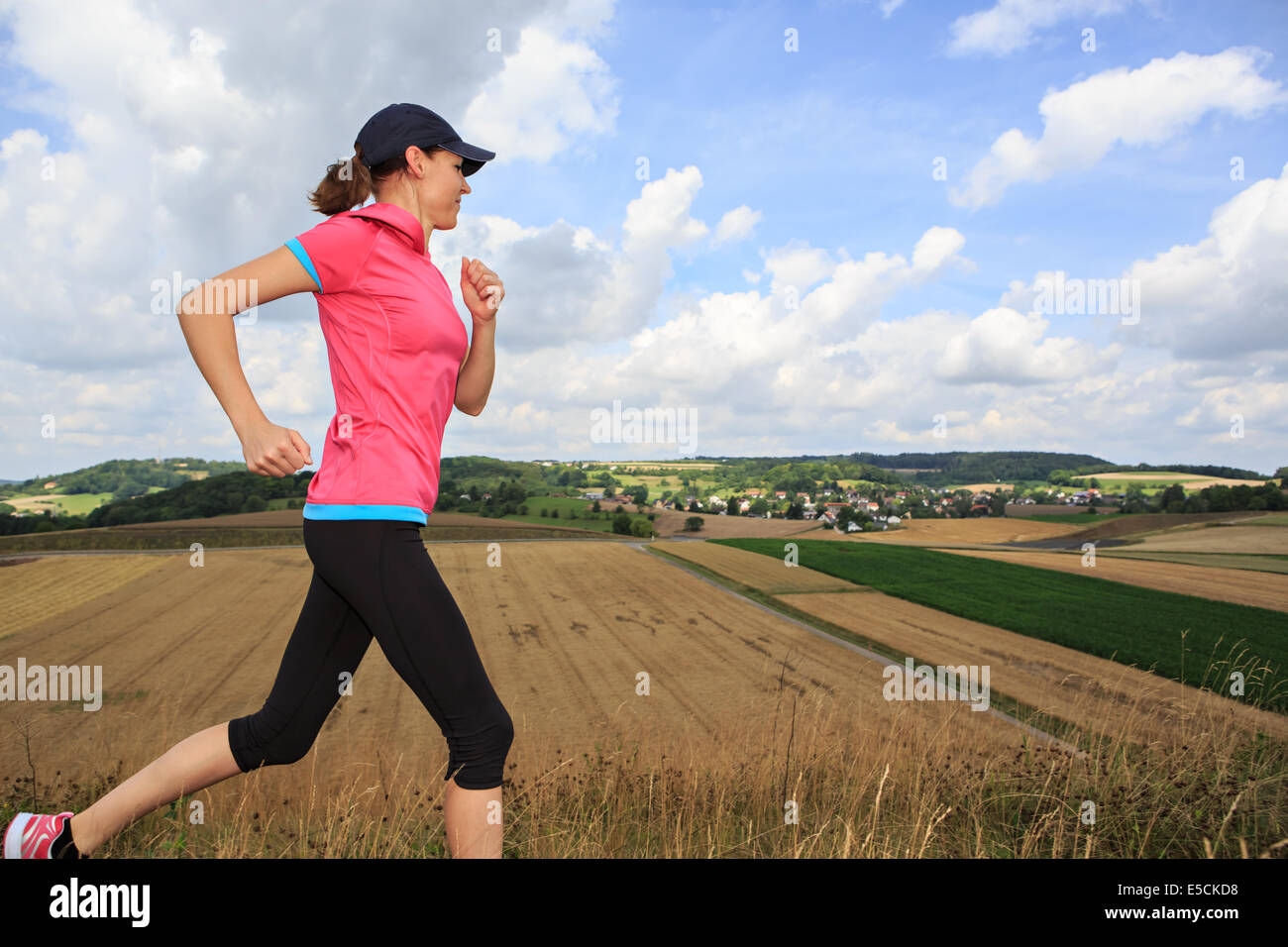 a woman running through the rural landscape Stock Photo - Alamy