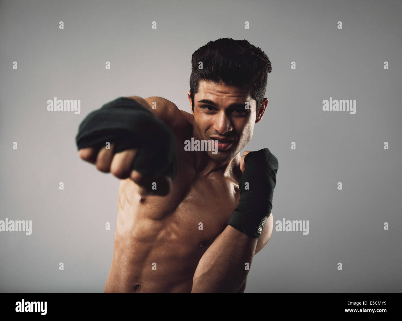 Tough young man doing some shadow boxing. Shirtless muscular man on ...