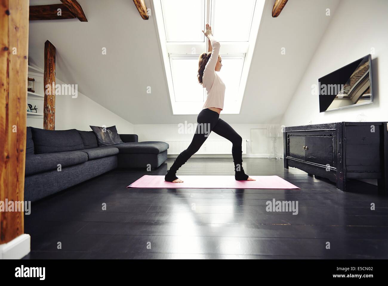 Fit young woman doing yoga at home. Healthy female model exercising in ...
