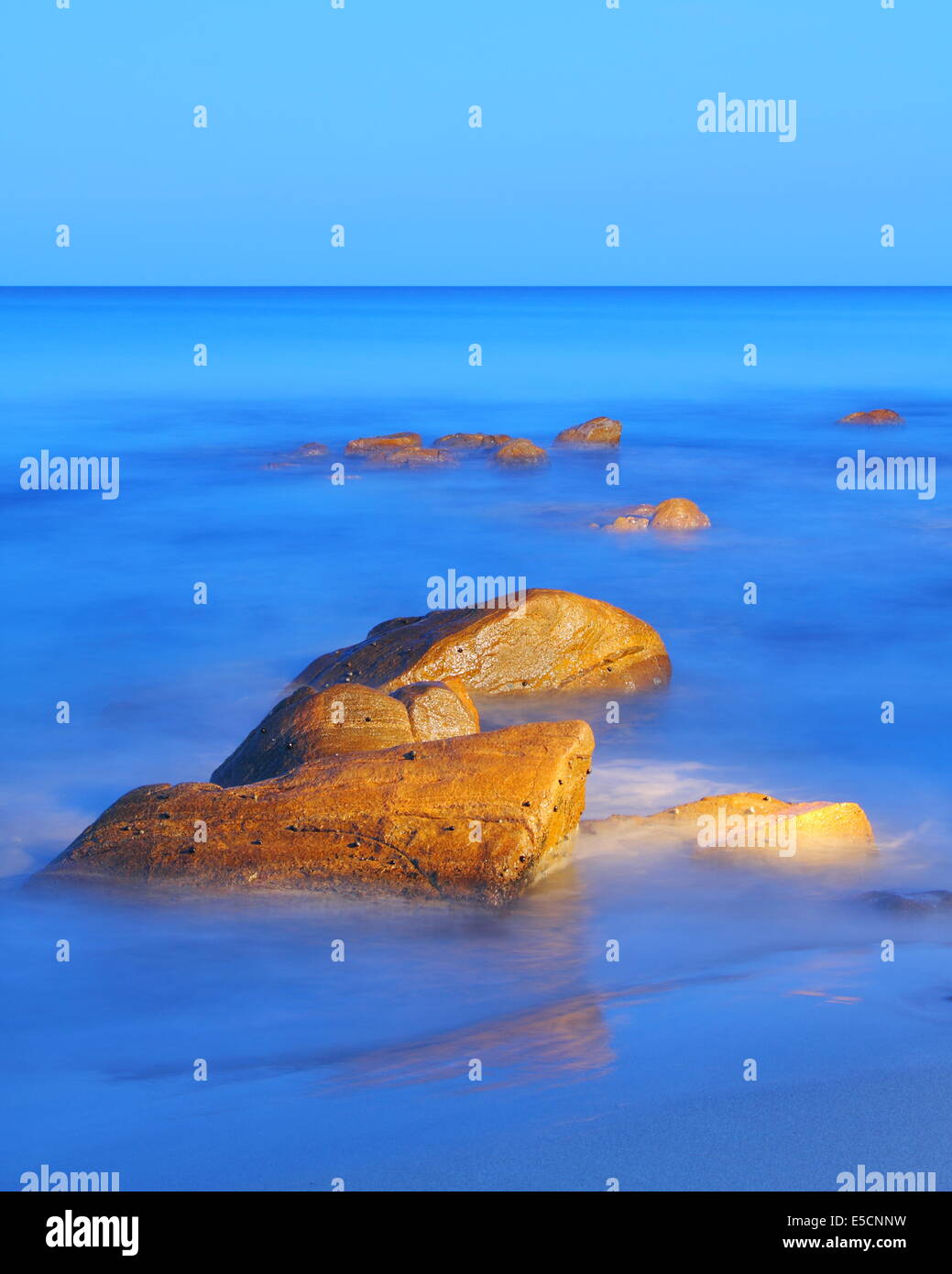 A light painting of oceanic rocks at the ocean edge during the blue ...