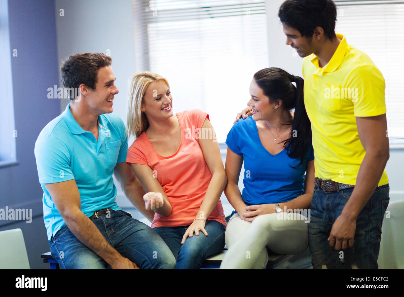 cheerful university students chatting in lecture hall during break ...