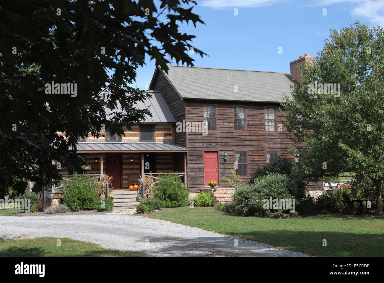 Historic log cabin with porch and addition, with driveway and lawn in ...