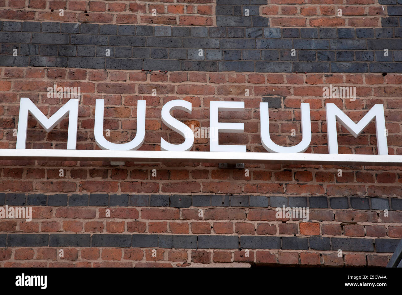 White Museum Sign on Brick Wall Stock Photo - Alamy