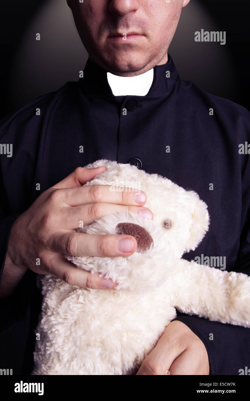 The priest holding a teddy bear Stock Photo - Alamy