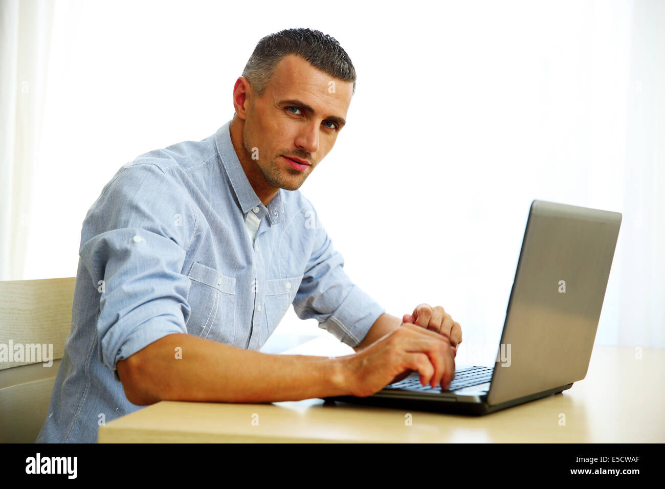 Handsome man using laptop at home Stock Photo - Alamy