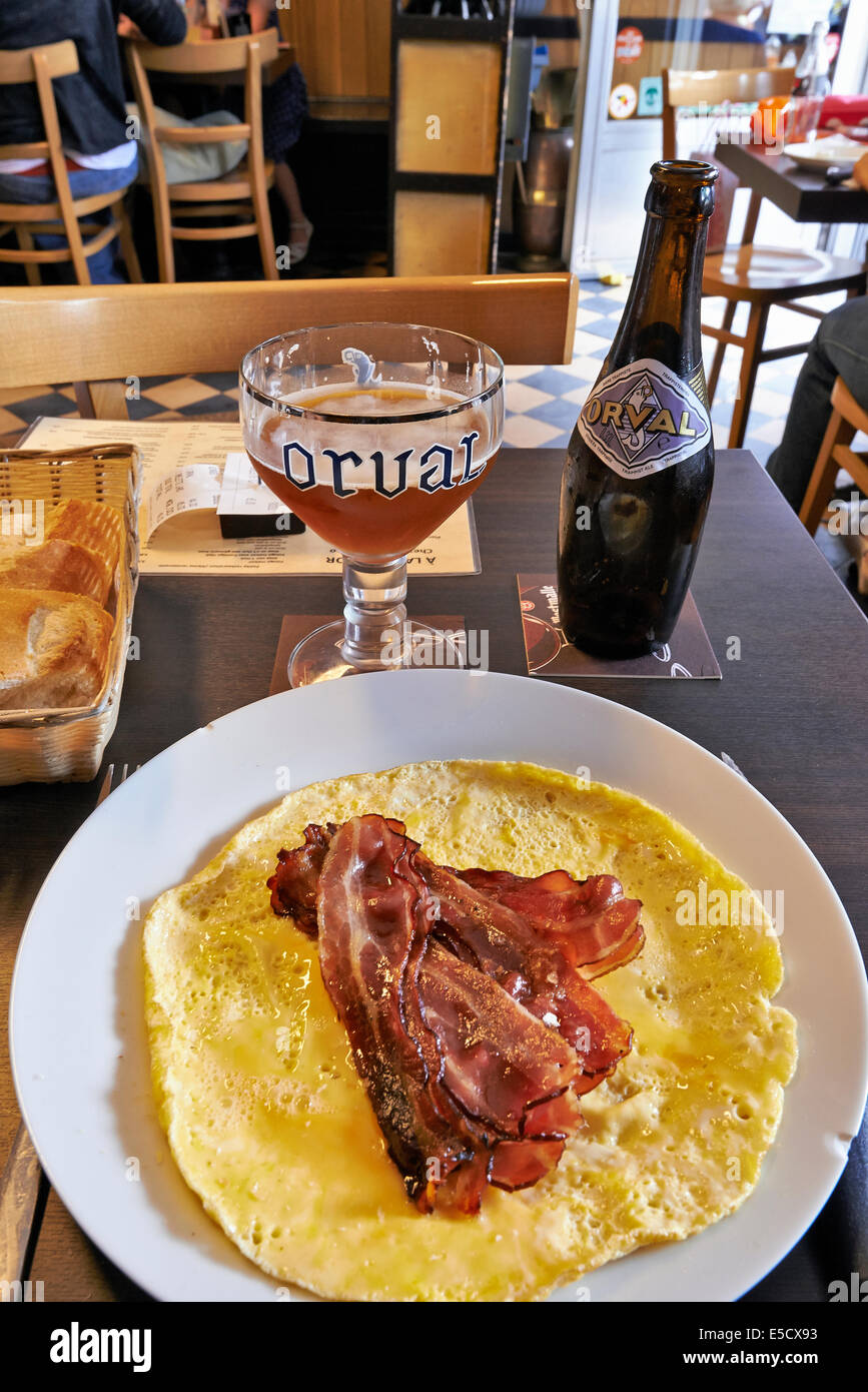 Orval Trappist Belgian Ale bottle and glass on a table with bacon and ...