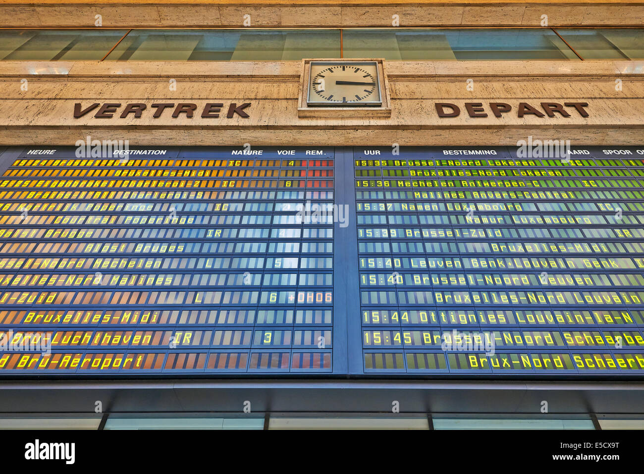 A schedule board in a train station with information telling the time ...