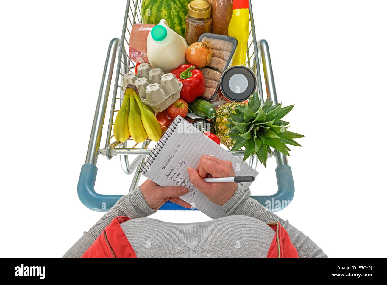 Overhead photo of a woman checking her shopping list with a trolley ...
