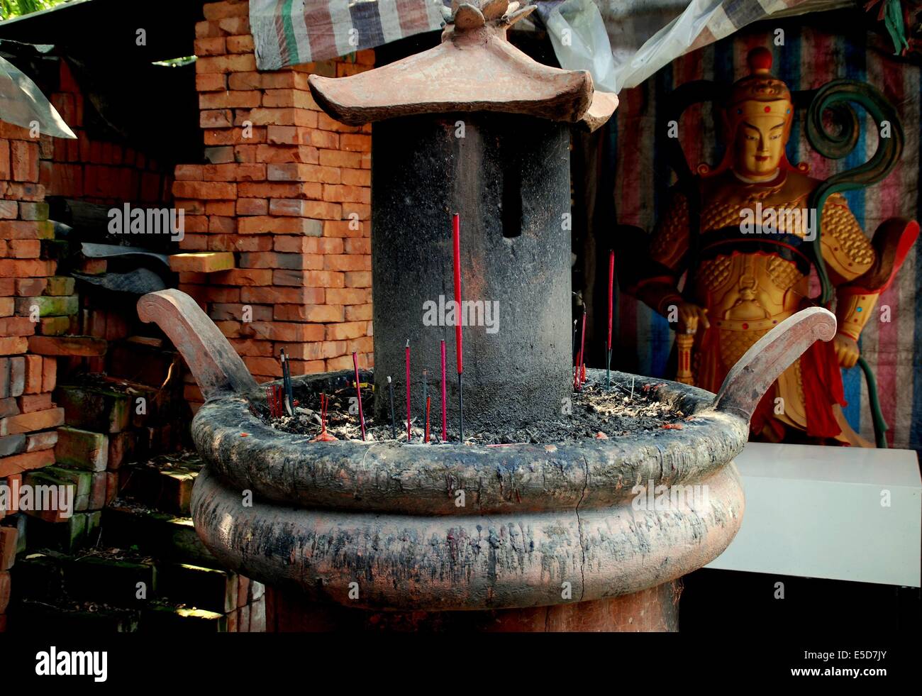 JIU CHI TOWN (SICHUAN), CHINA: Incense stocks burn in a ceramic brazier ...