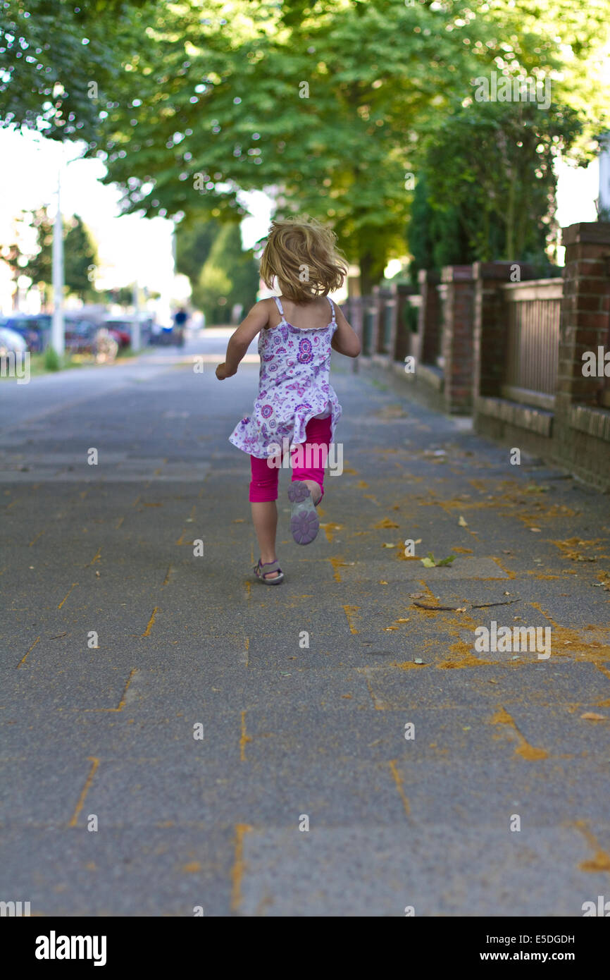 Little girl running on walkway Stock Photo - Alamy