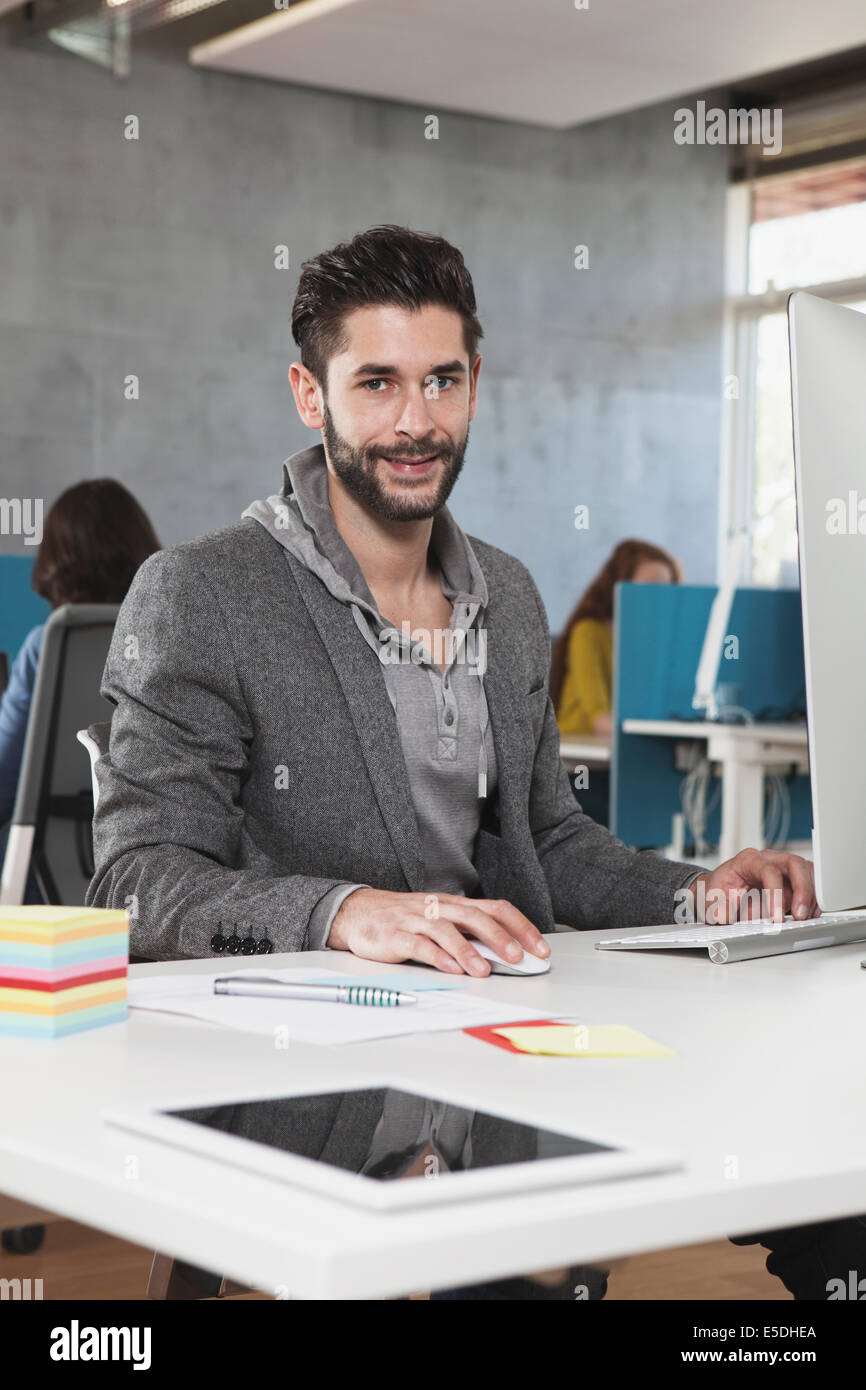 Portrait of smiling man at his workplace in the office Stock Photo - Alamy
