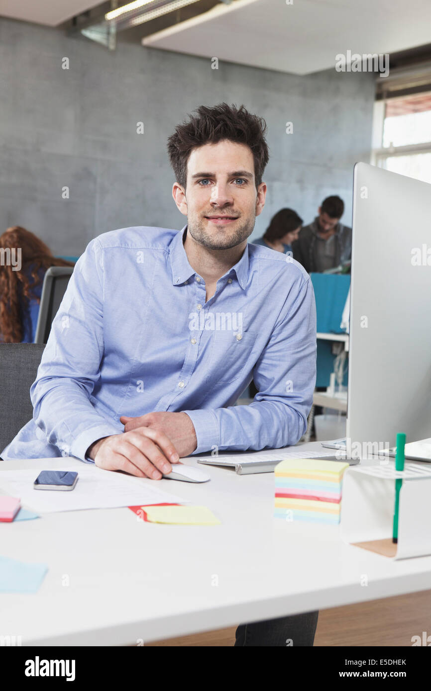 Portrait of smiling man at his workplace in the office Stock Photo - Alamy