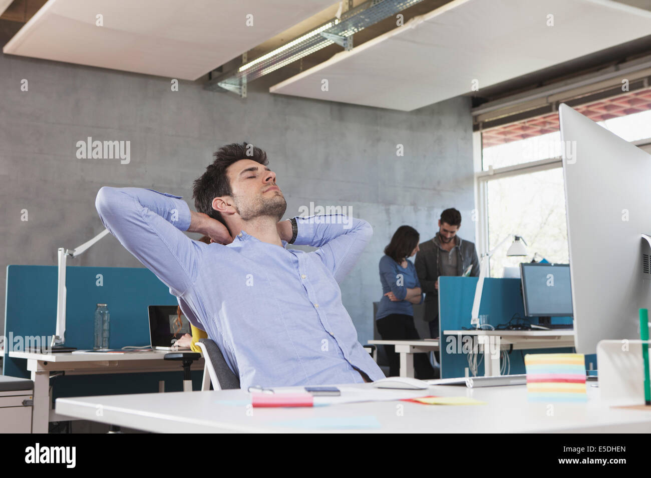 Portrait of man relaxing at his workplace in the office Stock Photo - Alamy