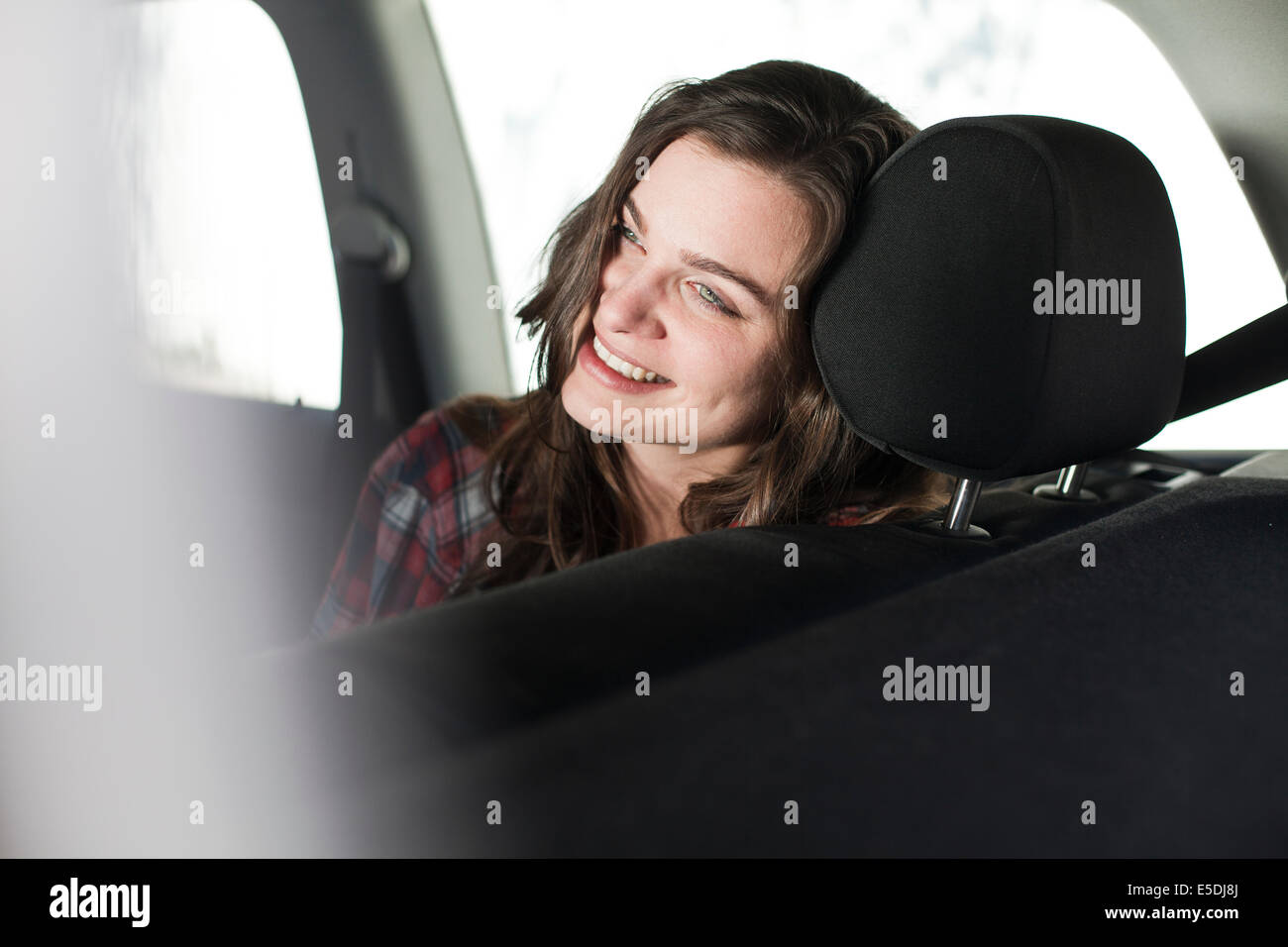 Smiling young woman on back seat of a car Stock Photo - Alamy