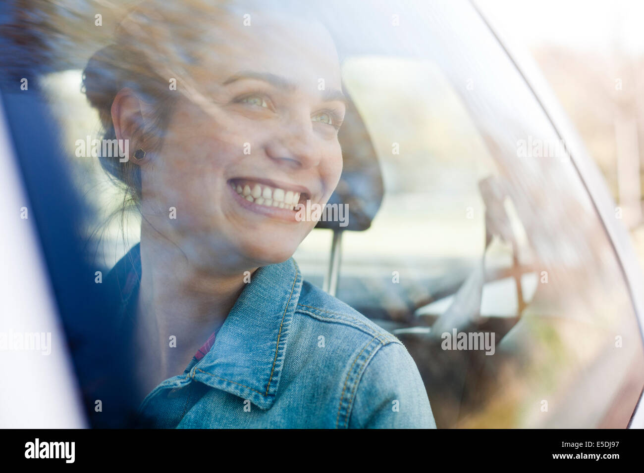 Smiling young woman on back seat of a car Stock Photo - Alamy