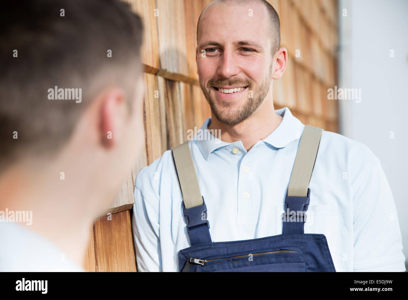Two craftsmen at wooden wall Stock Photo - Alamy