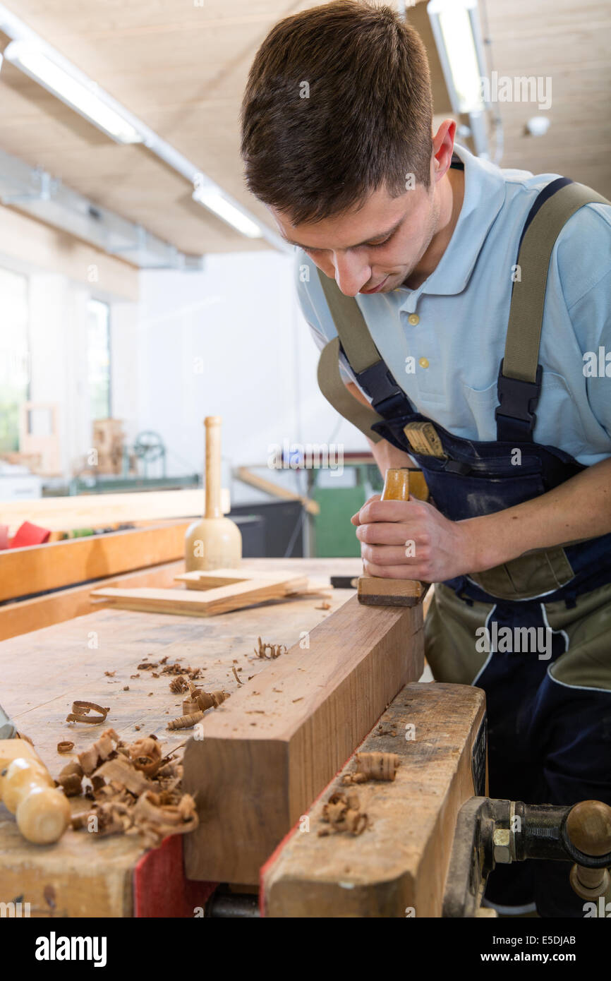 Carpenter planing wood in workshop Stock Photo - Alamy