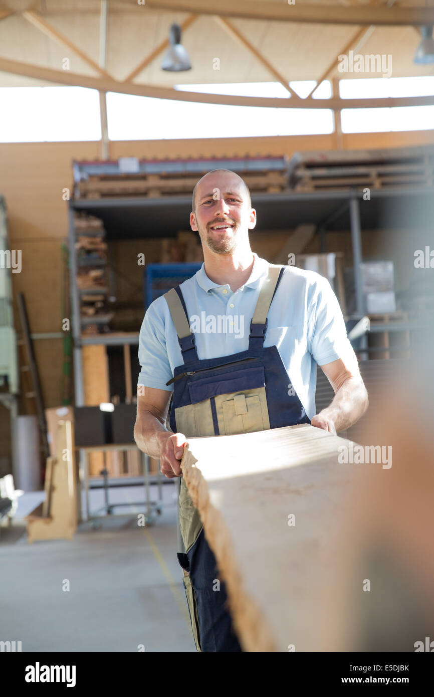 Two carpenters carrying wooden board Stock Photo - Alamy
