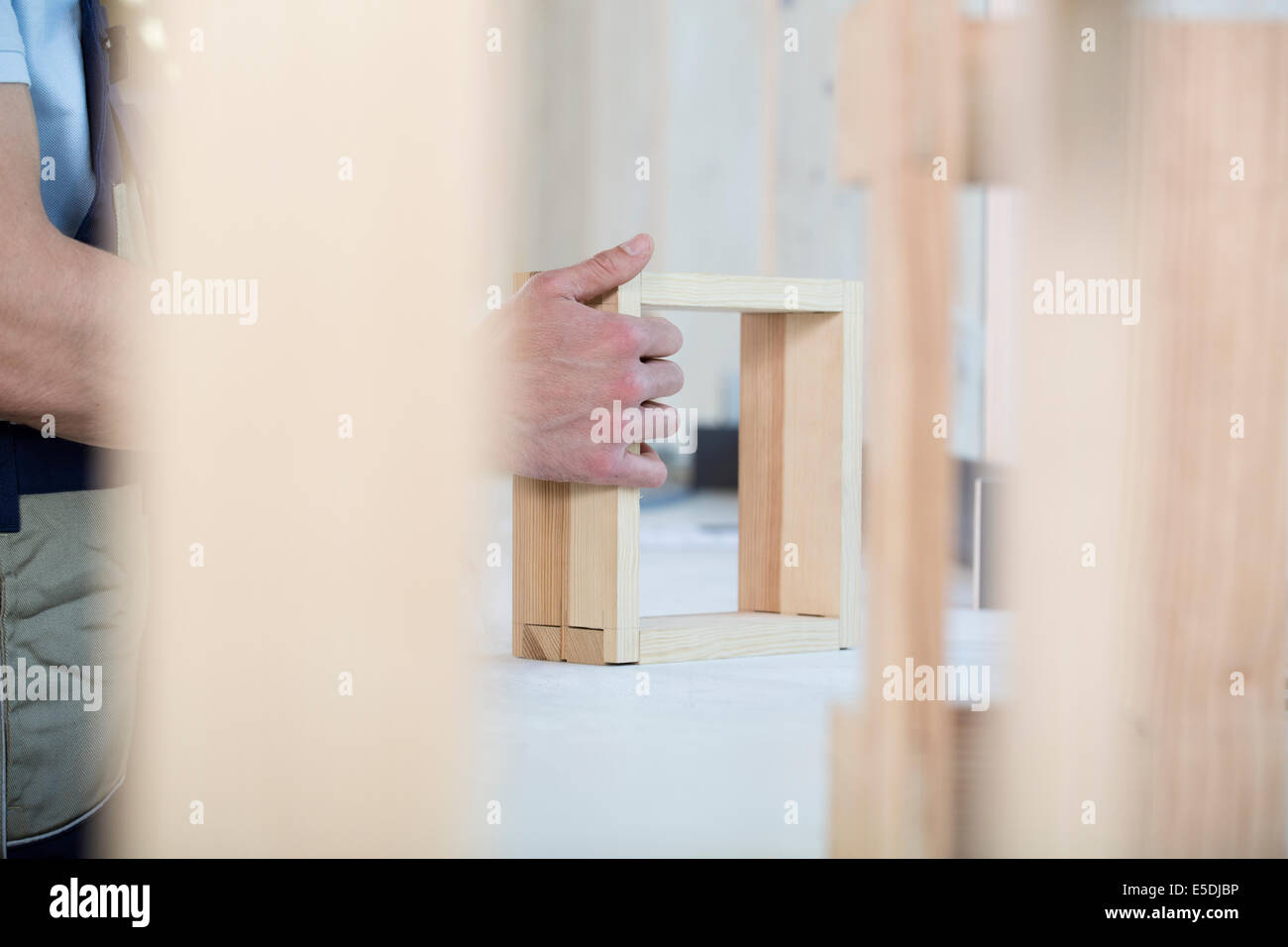 Carpenter holding piece of wood Stock Photo - Alamy