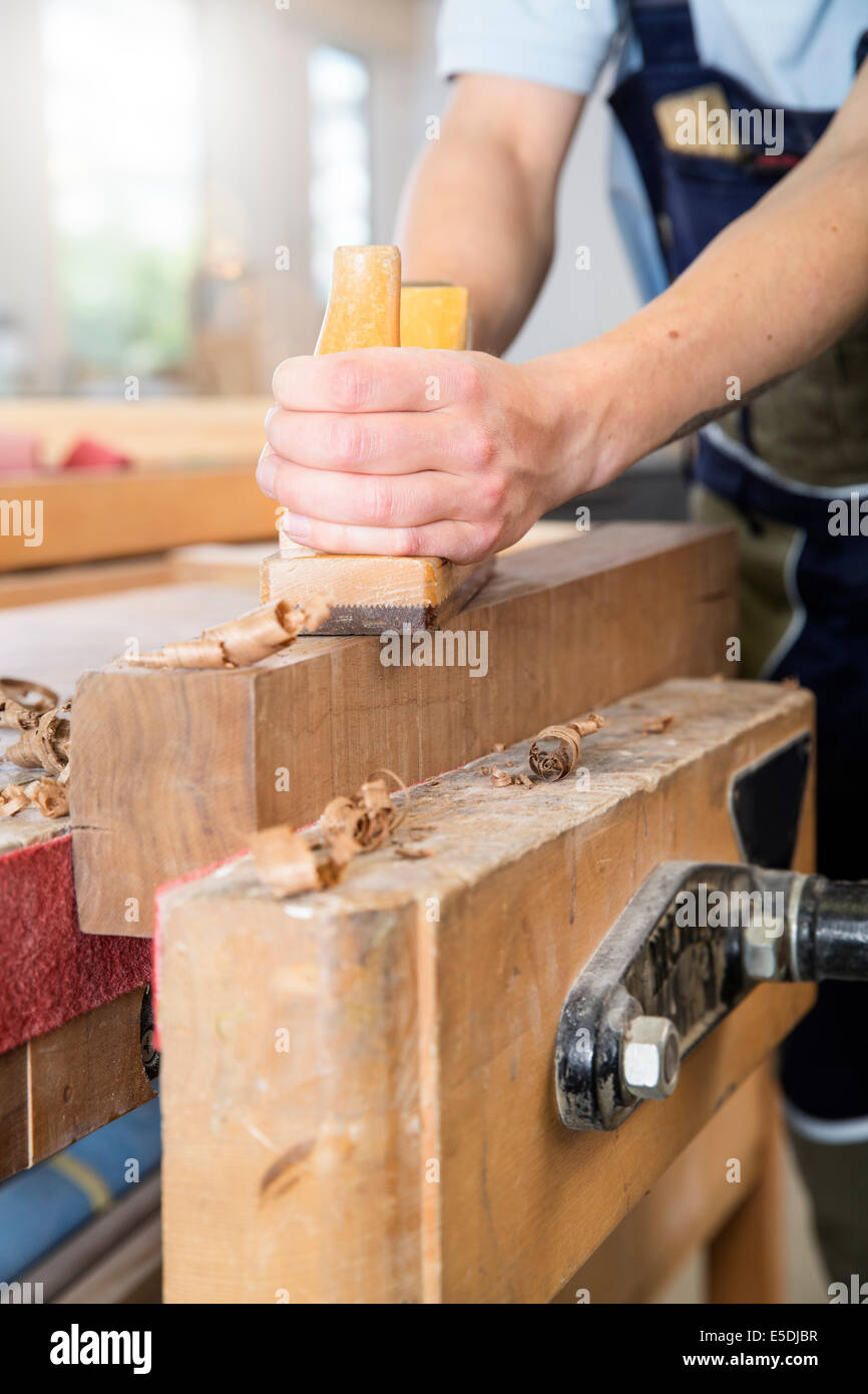 Carpenter planing wood in workshop Stock Photo - Alamy