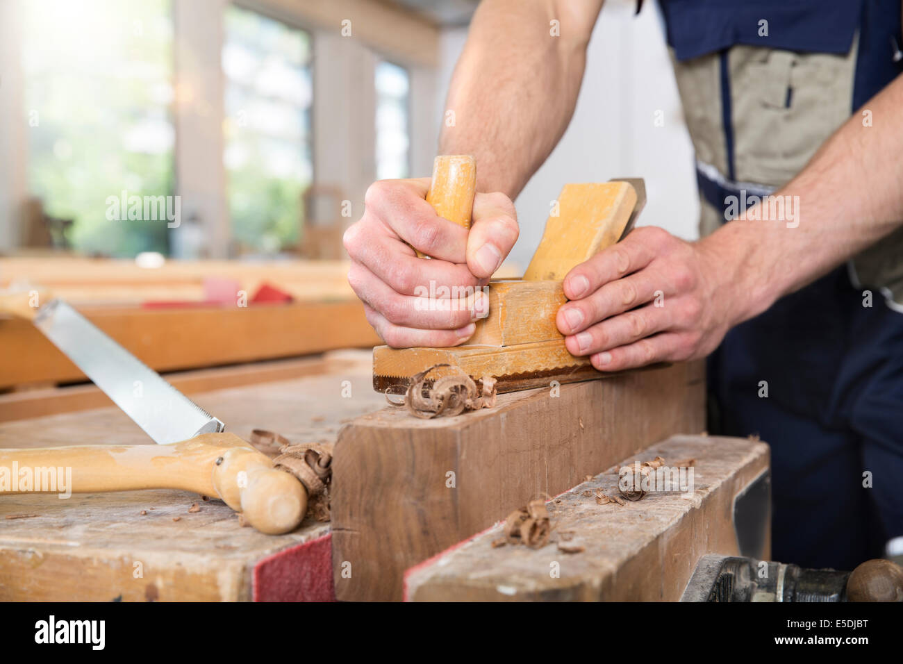 Carpenter planing wood in workshop Stock Photo - Alamy
