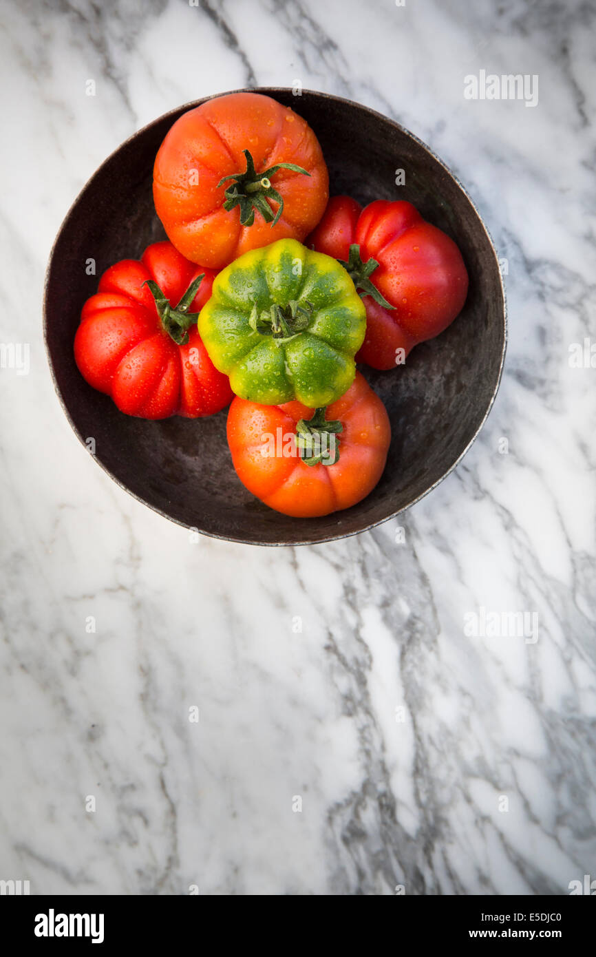 Marinda tomatoes in bol on marble plate Stock Photo - Alamy