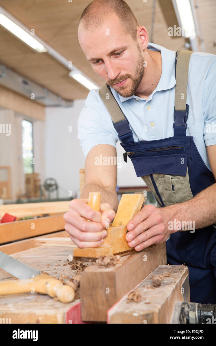 Carpenter planing wood in workshop Stock Photo - Alamy