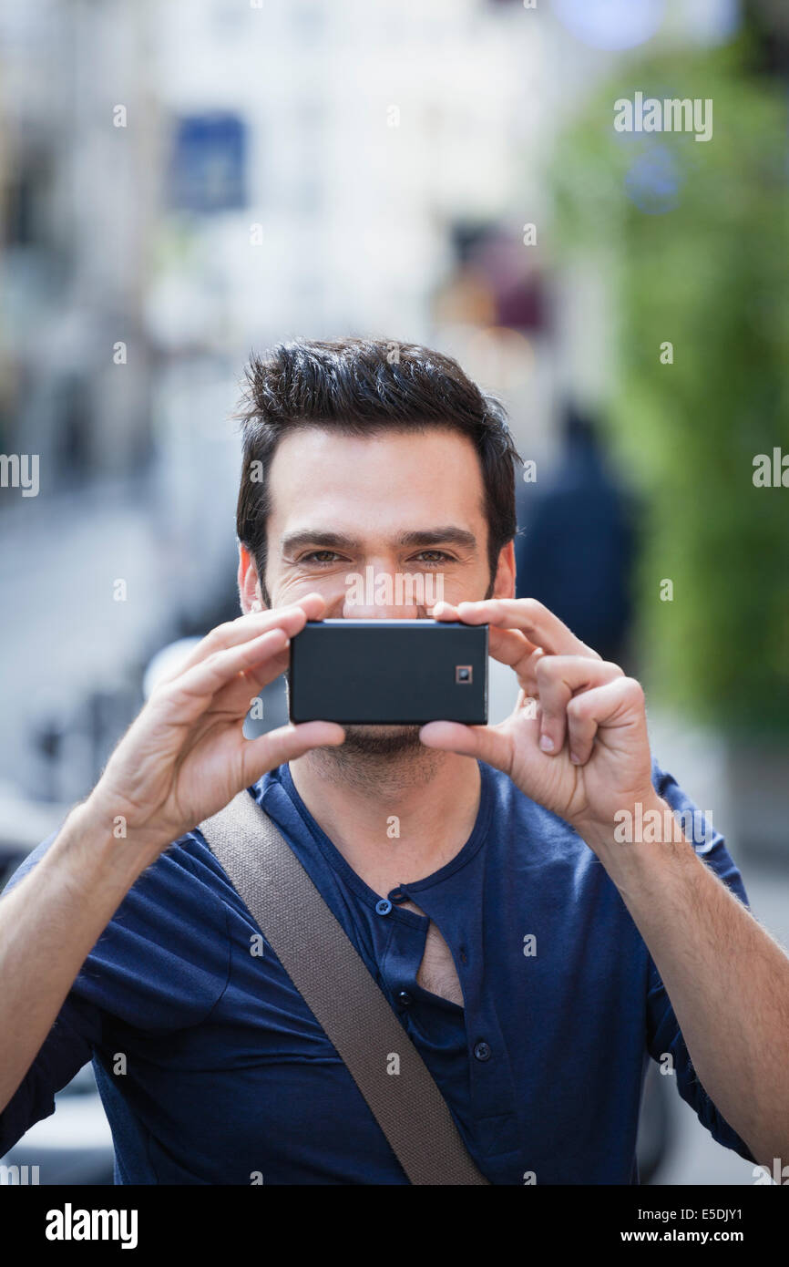 France, Paris, portrait of man photographing with his smartphone Stock ...