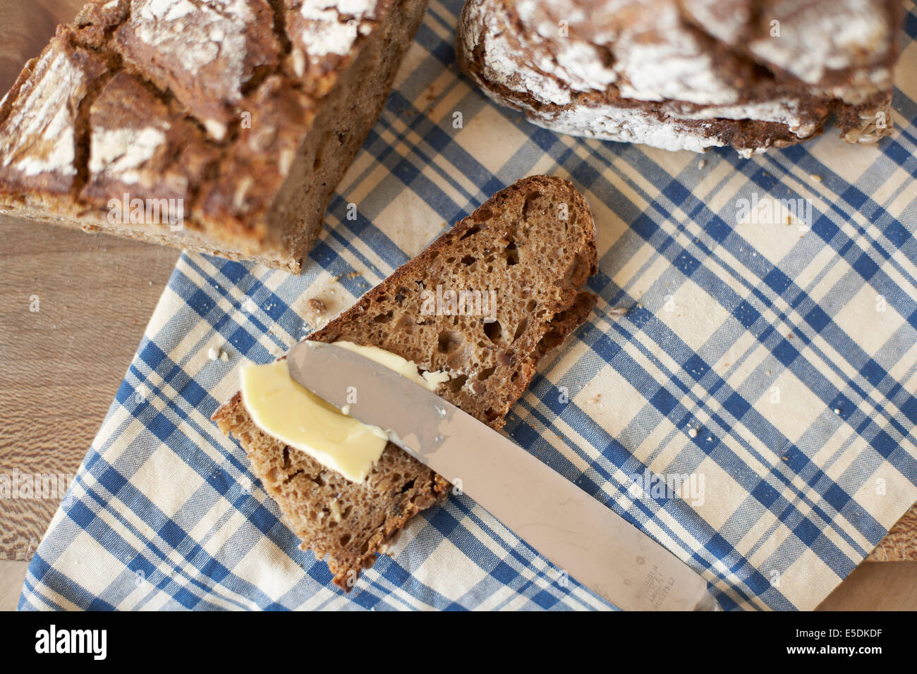Buttering slice of wholemeal bread, elevated view Stock Photo - Alamy