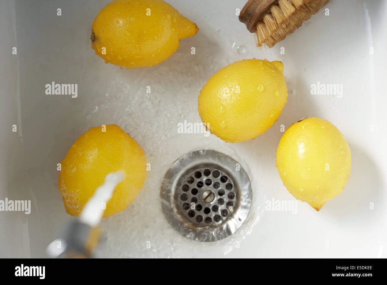 Cleaning lemons with vegetable brust in sink, elevated view Stock Photo ...