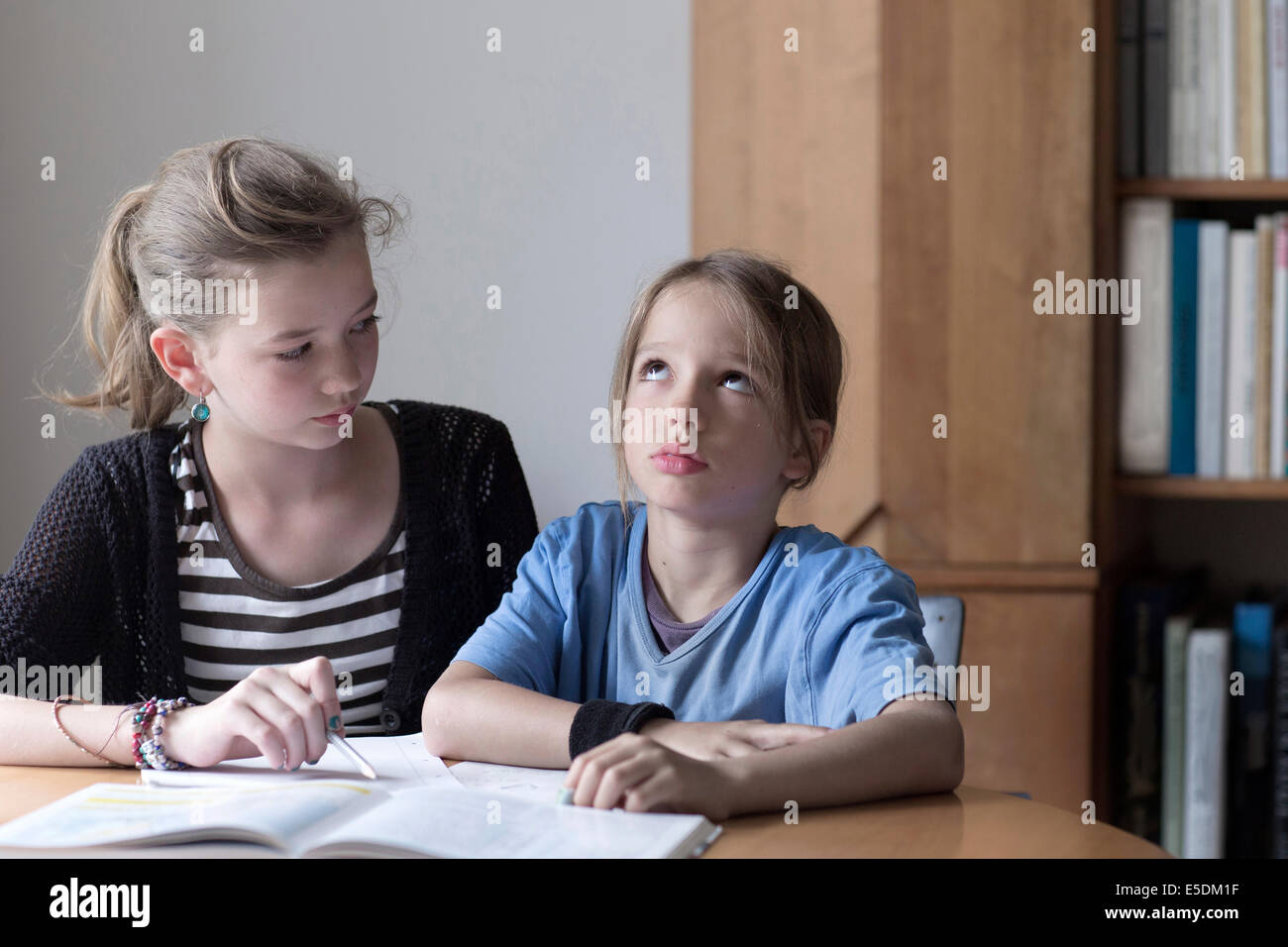 Sister helping her little brother by doing his homework Stock Photo - Alamy