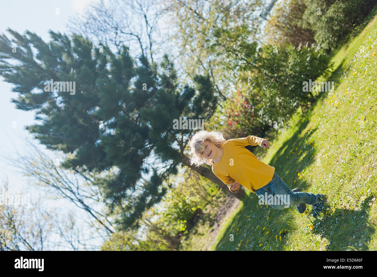 Boy running in garden Stock Photo - Alamy