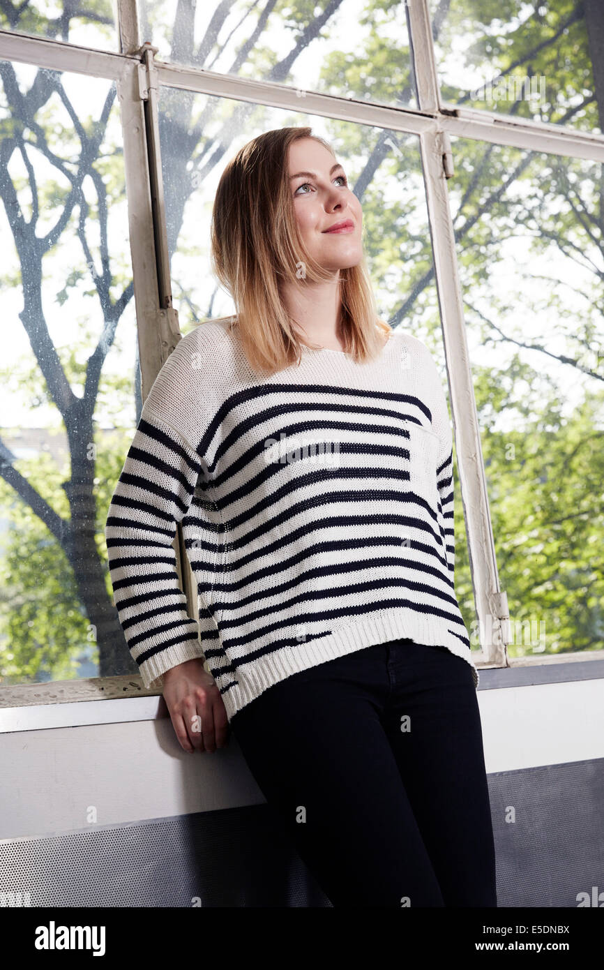 Woman at a window thinking Stock Photo - Alamy