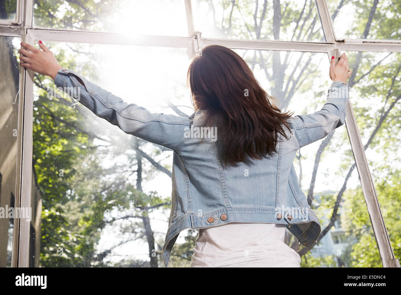 Woman at a window looking out Stock Photo - Alamy