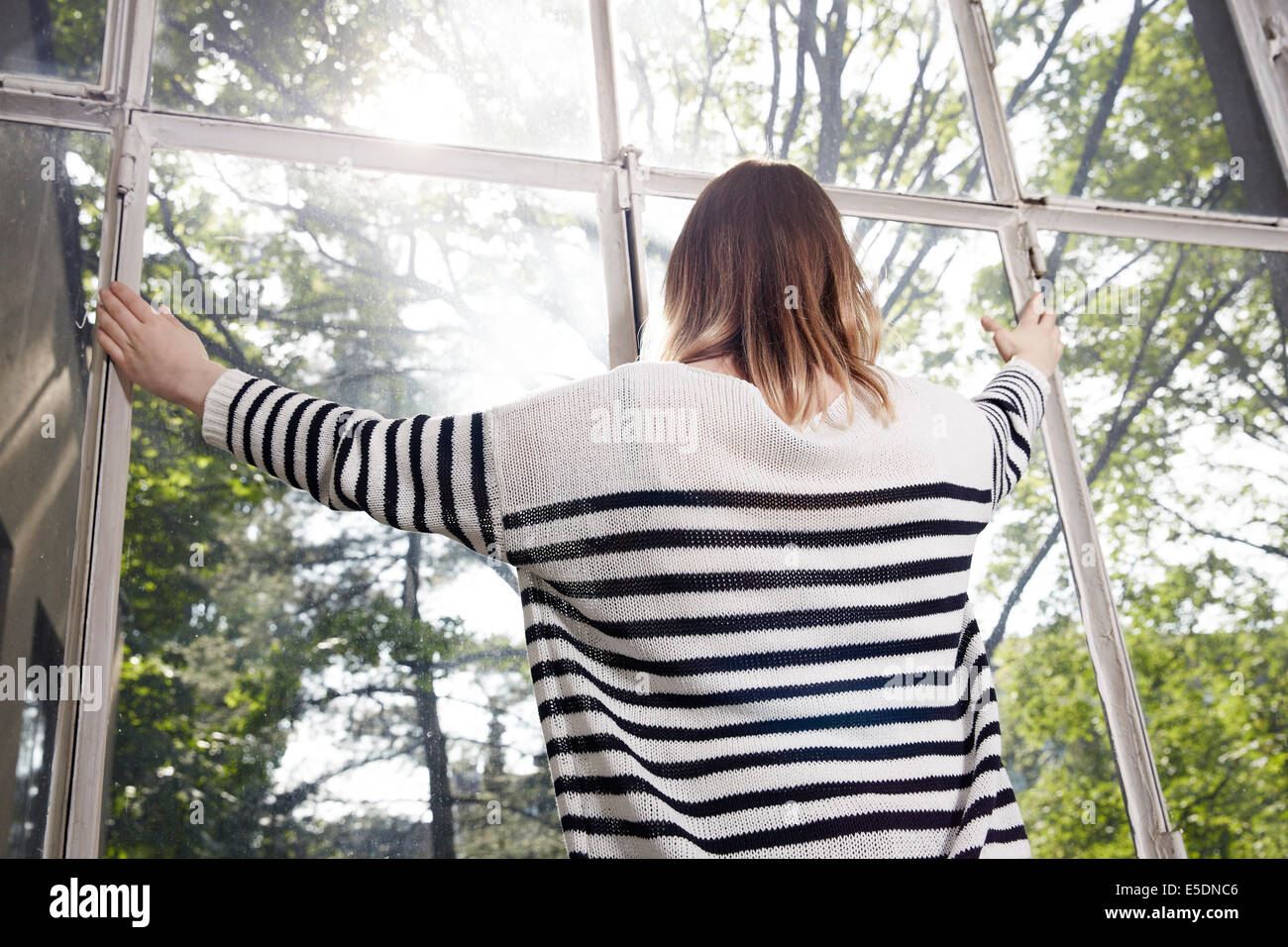 Woman at a window looking out Stock Photo - Alamy