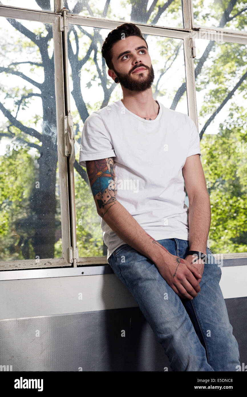 Man at a window thinking Stock Photo - Alamy