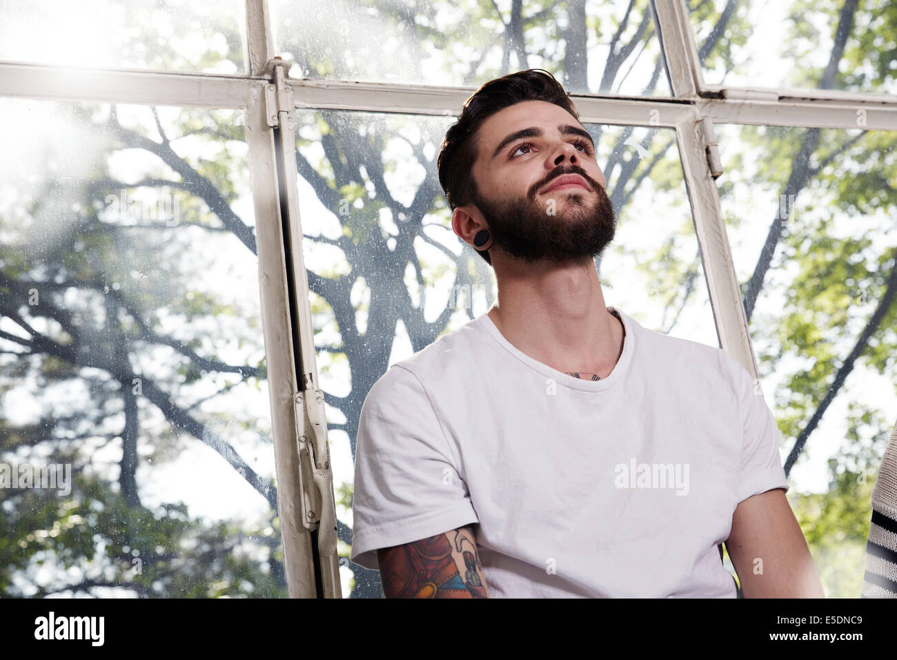 Man at a window thinking Stock Photo - Alamy