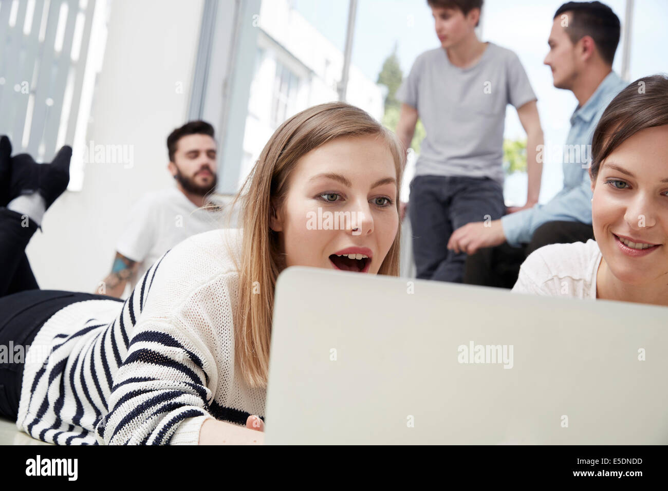 Group of creative professionals using laptop on floor Stock Photo - Alamy
