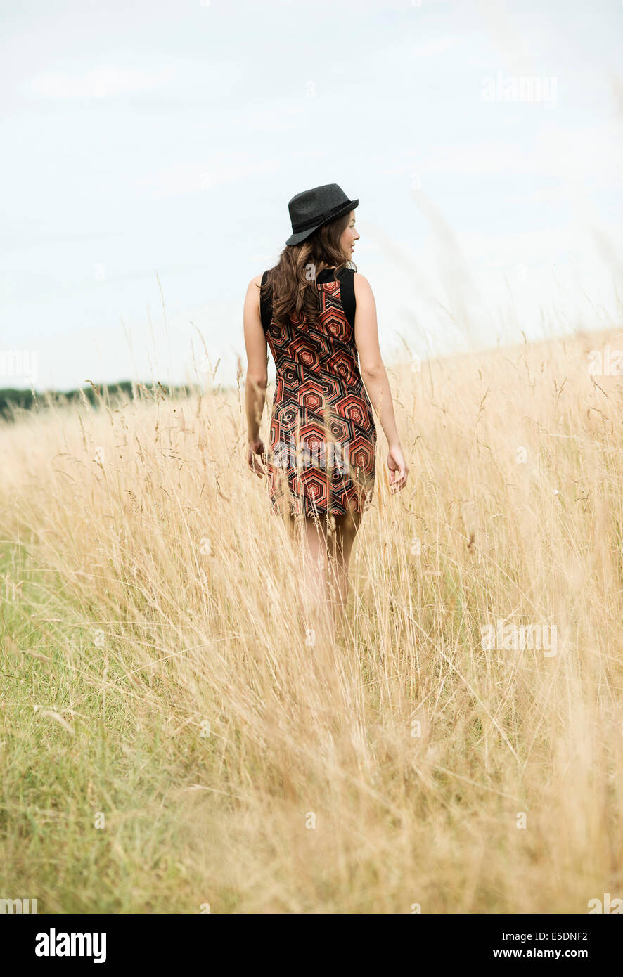 Young woman walking on an autumnal meadow, back view Stock Photo - Alamy