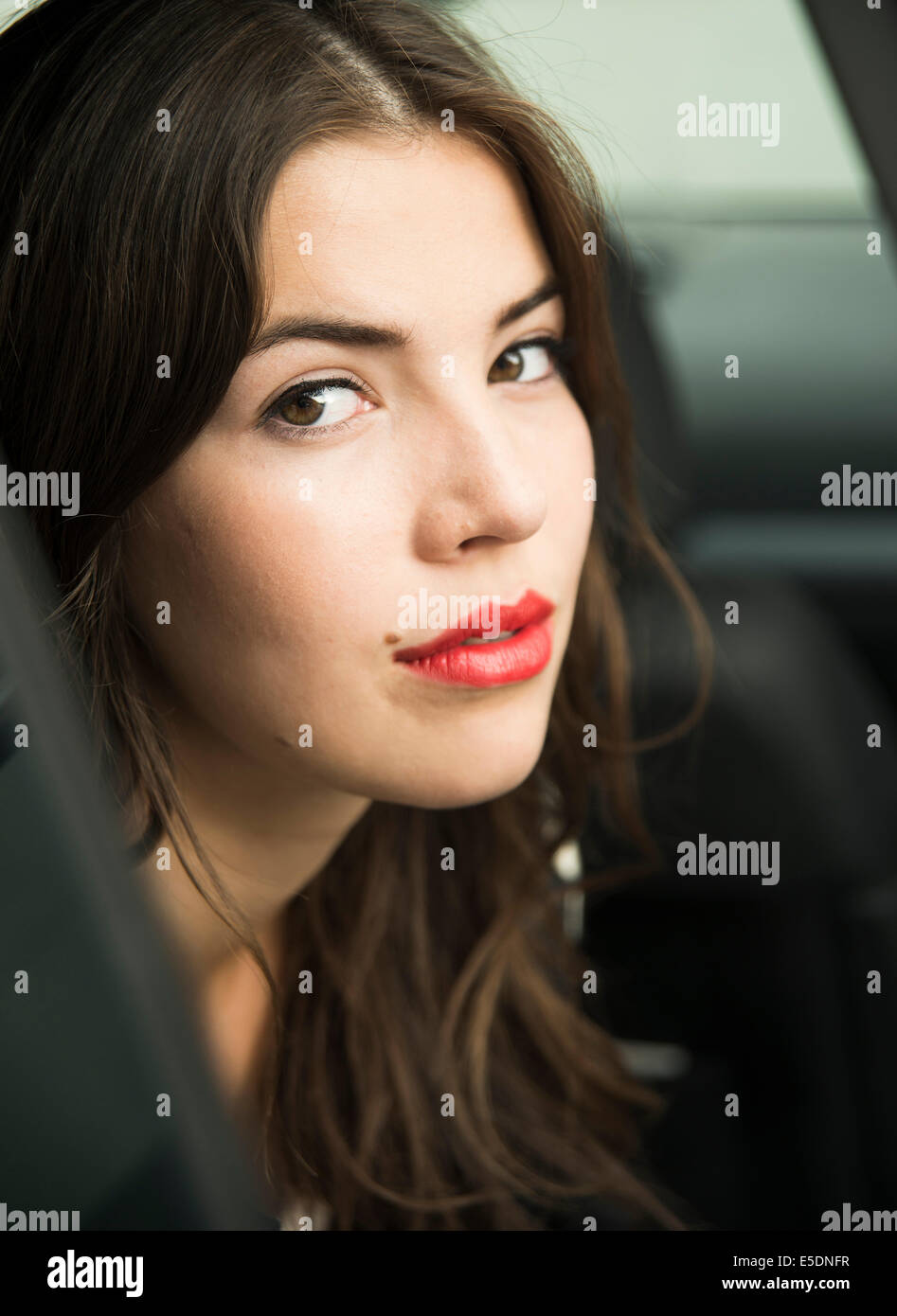 Portrait of young woman with red lips sitting in car Stock Photo - Alamy