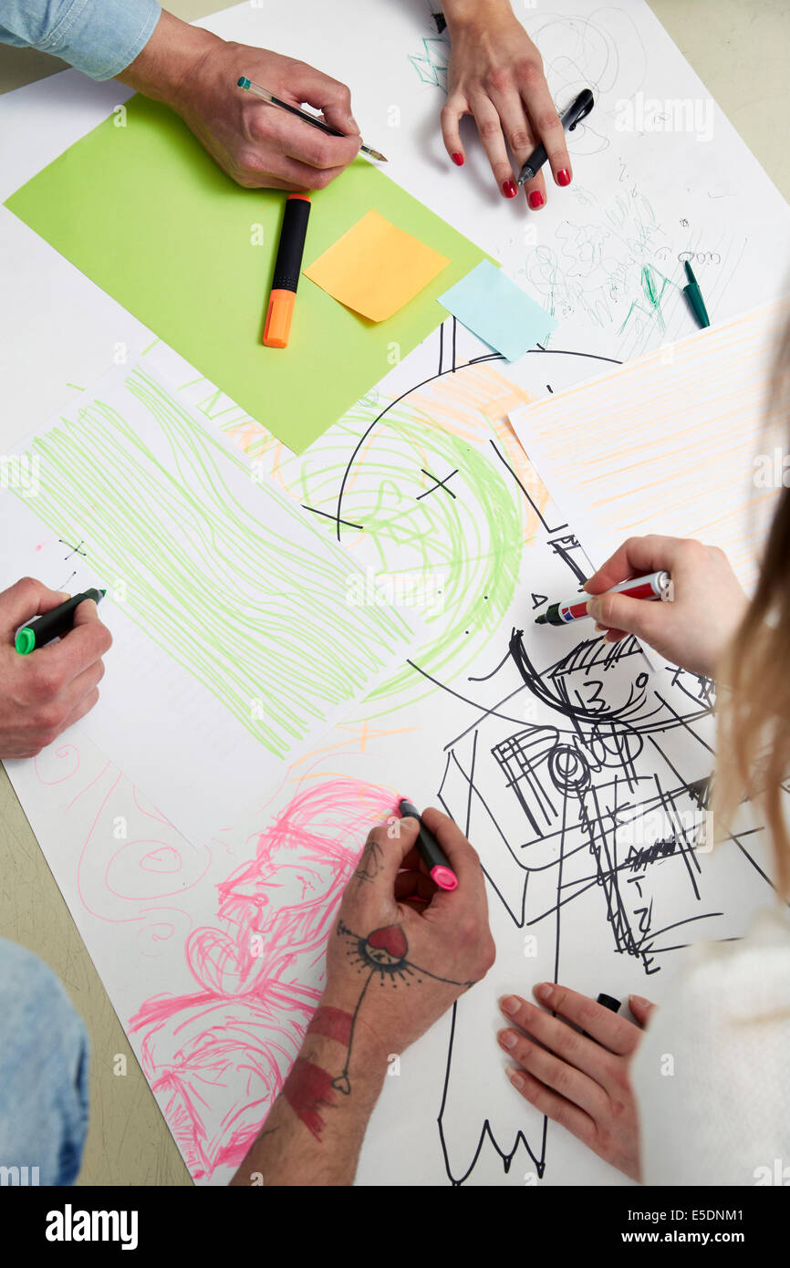 Creative professionals drawing on paper Stock Photo - Alamy